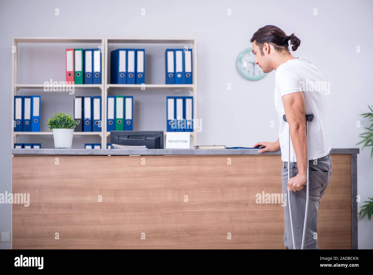 Young man at hospital reception desk Stock Photo - Alamy