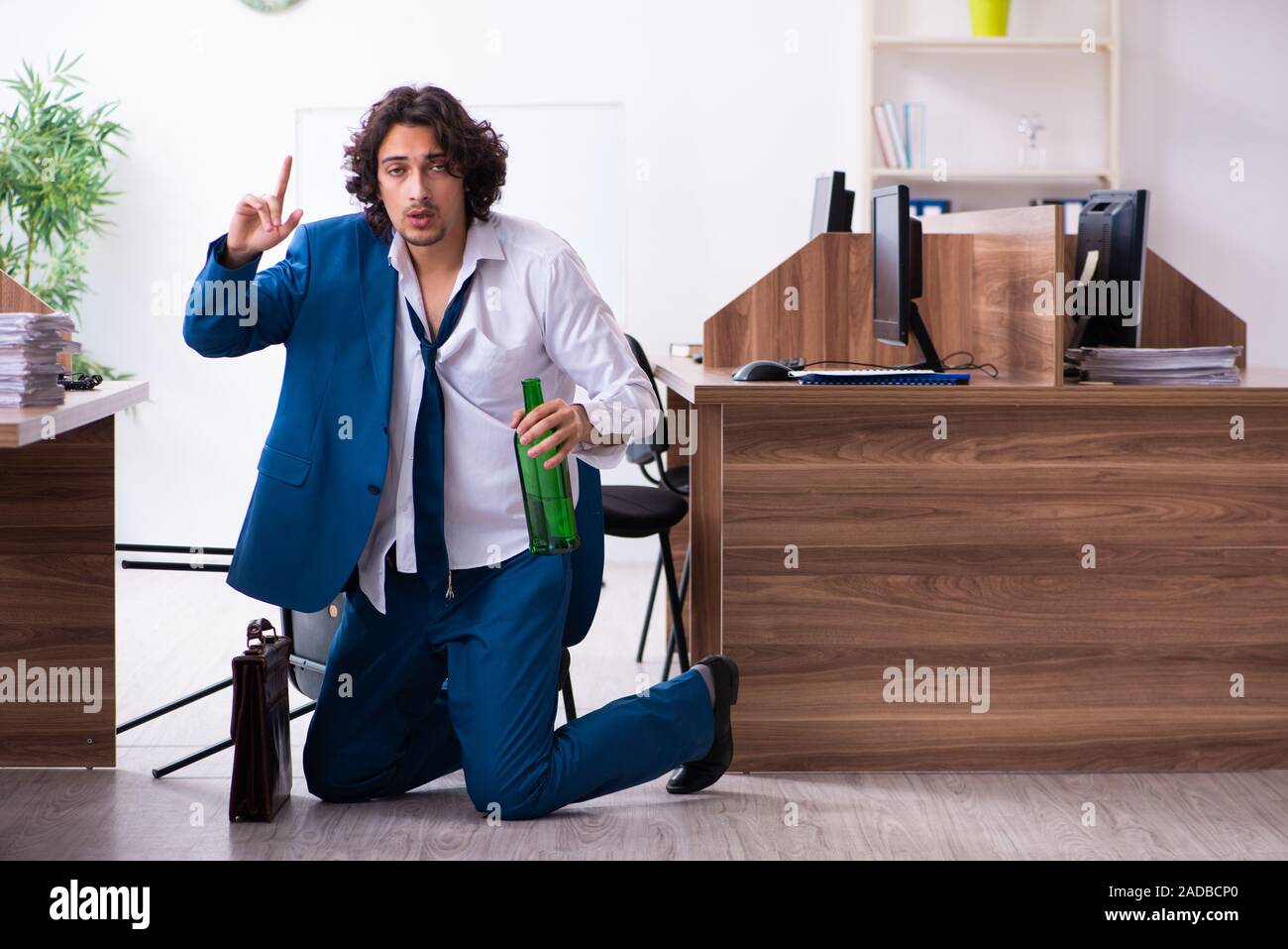 Young drunk employee in the office Stock Photo - Alamy