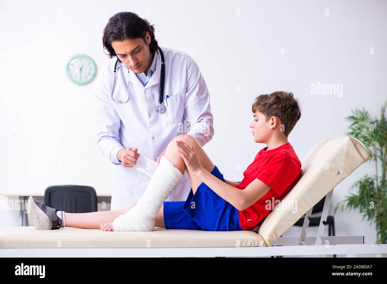 Leg injured boy visiting young doctor traumatologist Stock Photo - Alamy