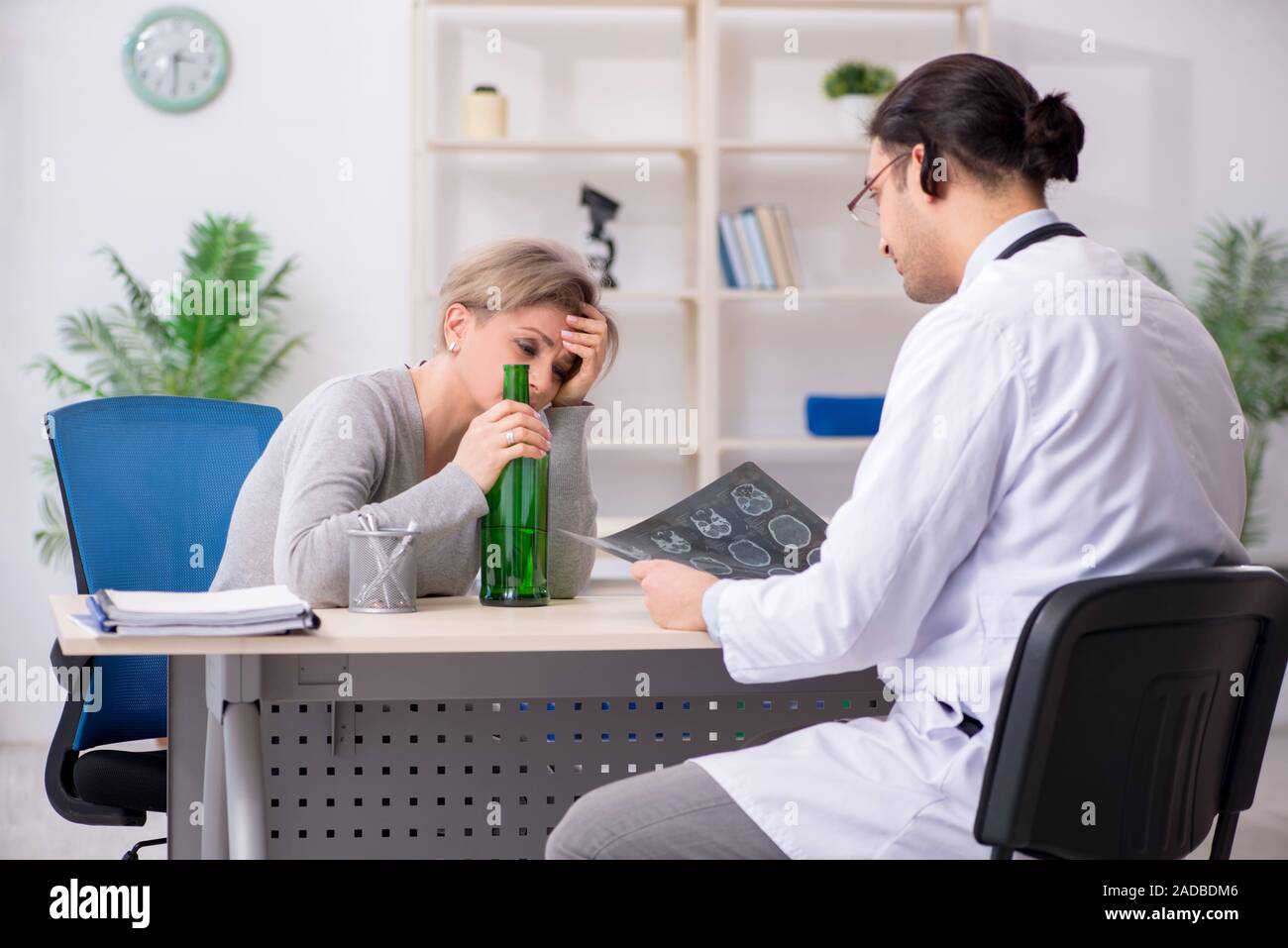 Female alcoholic visiting young male doctor Stock Photo - Alamy