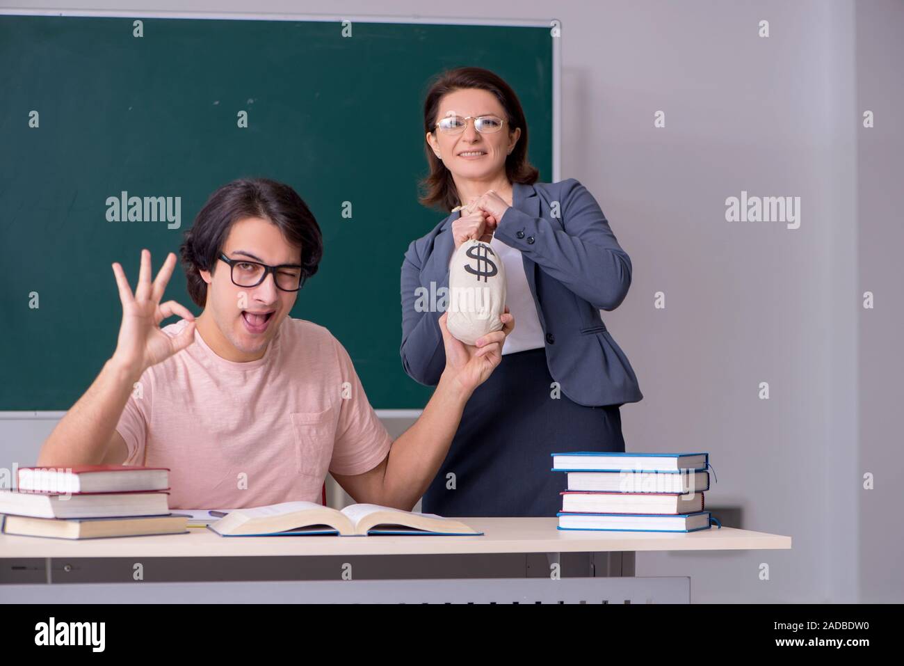 Old female teacher and male student in the classroom Stock Photo - Alamy