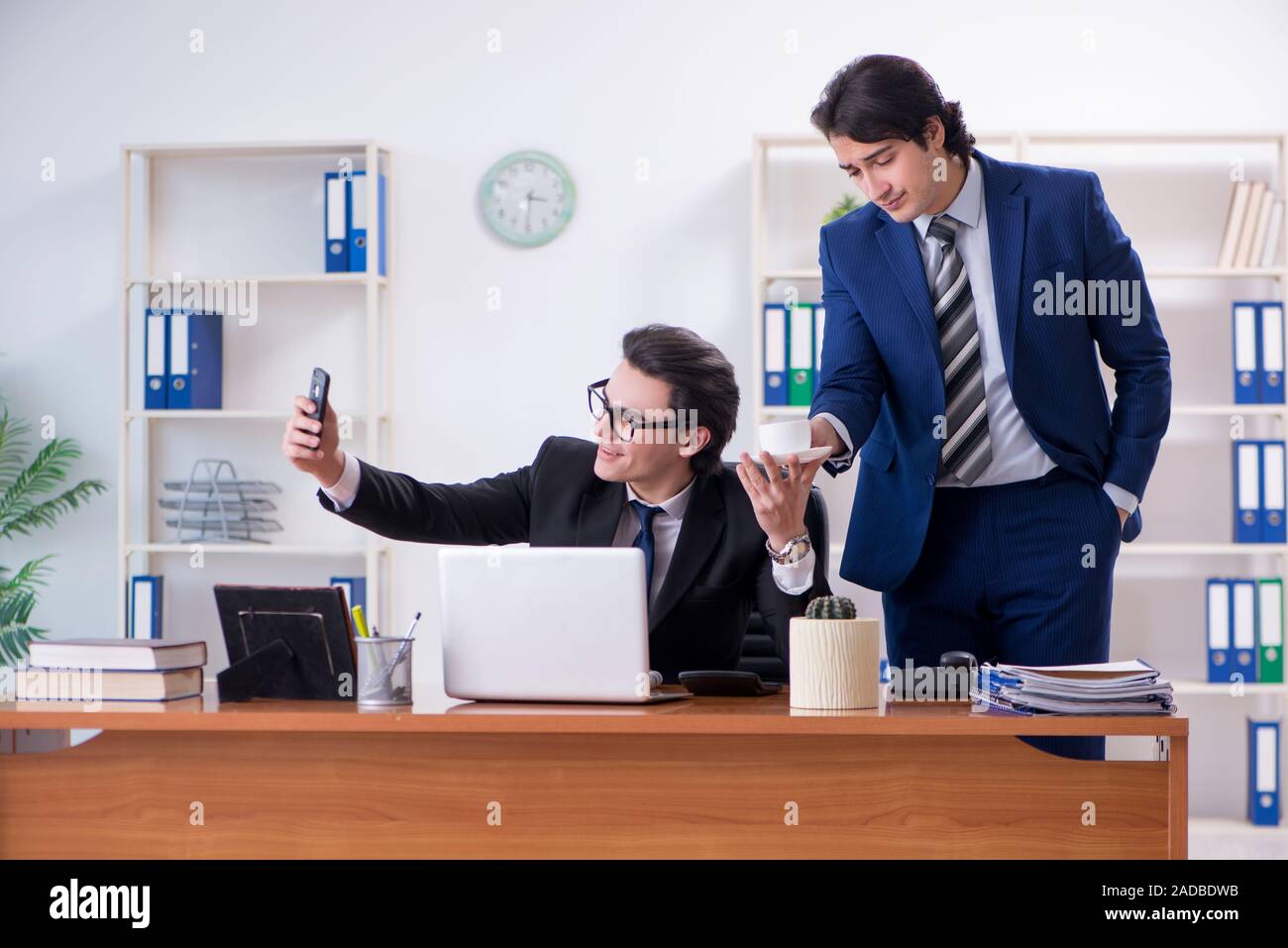 Boss and his male assistant working in the office Stock Photo - Alamy