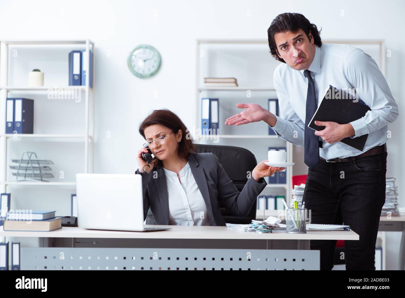 Old female boss and young male employee in the office Stock Photo - Alamy