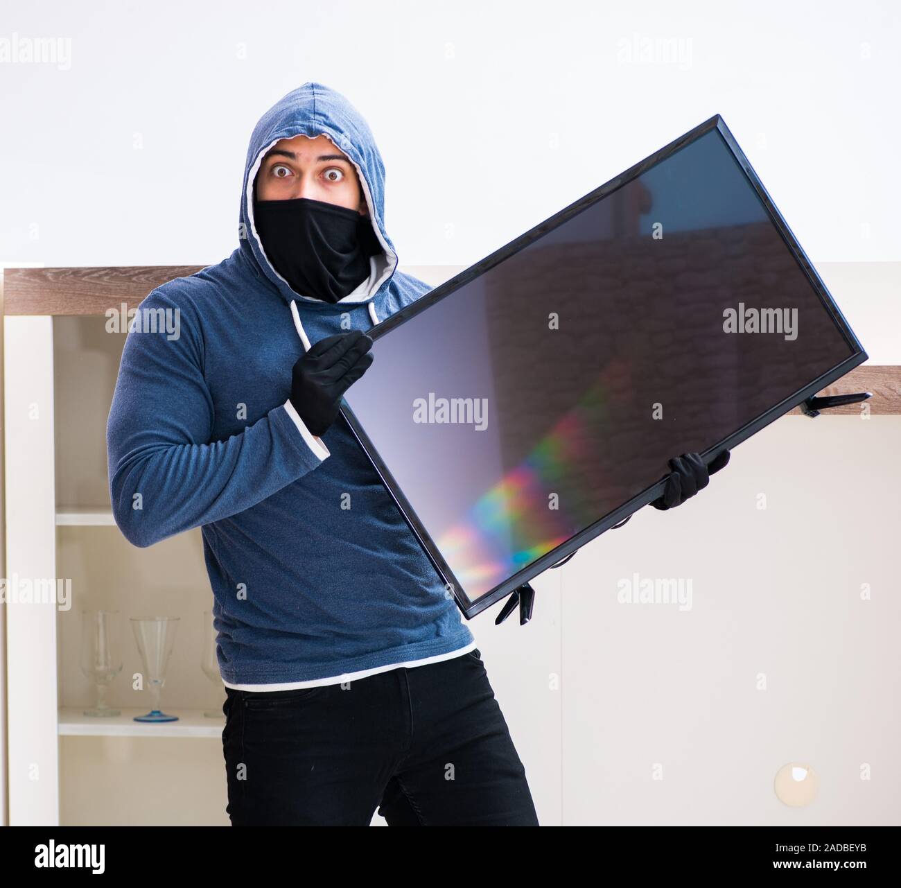 Man burglar stealing tv set from house Stock Photo - Alamy