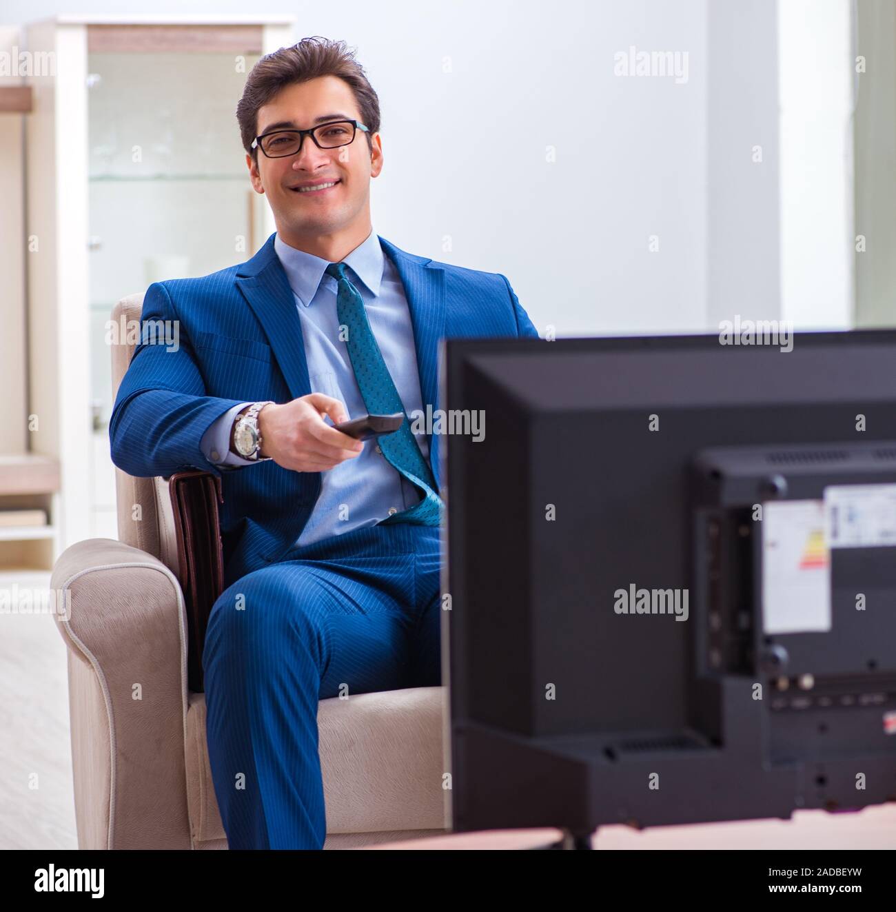 Businesman watching tv in office Stock Photo - Alamy
