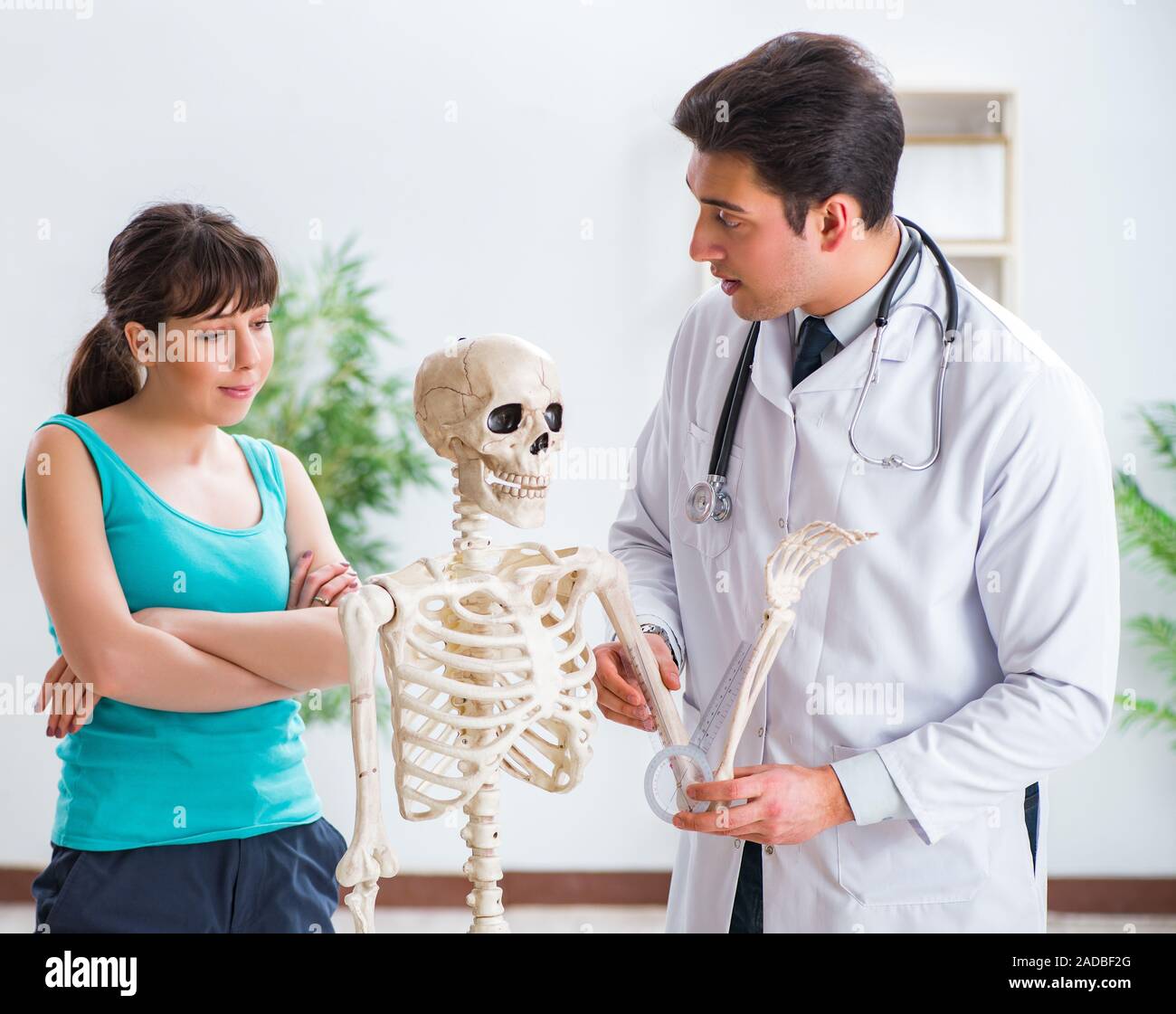 Doctor showing type of injury on skeleton to patient Stock Photo - Alamy
