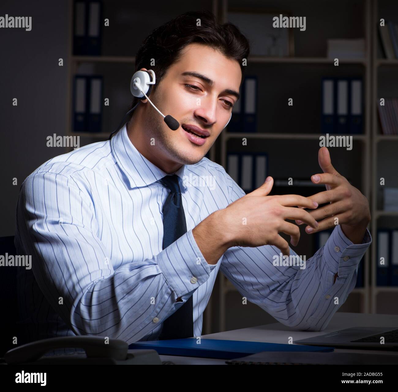 Call center operator talking to customer during night shift Stock Photo ...
