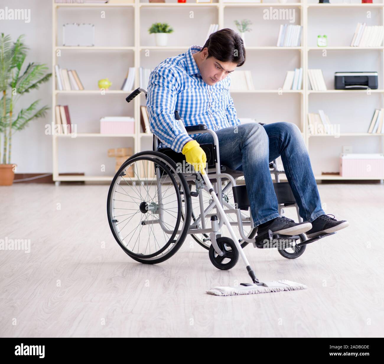 Disabled man on wheelchair cleaning home Stock Photo - Alamy