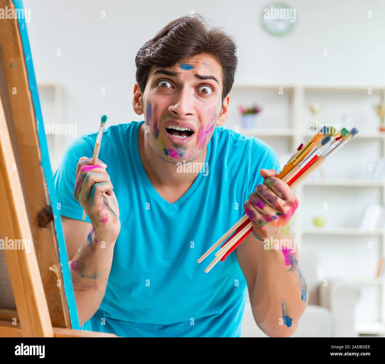 Young funny artist working on new painting in his studio Stock Photo ...