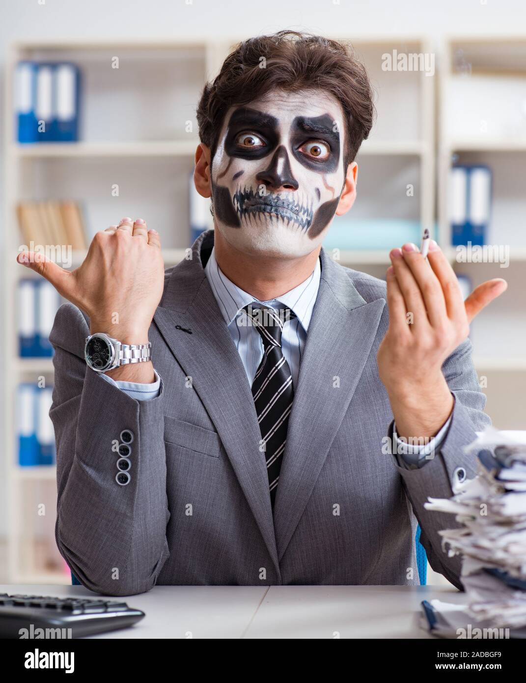 Businessmsn with scary face mask working in office Stock Photo - Alamy