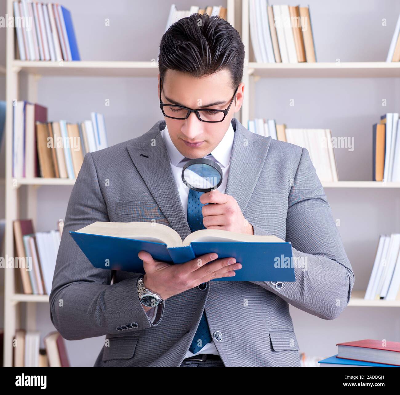 Business law student with magnifying glass reading a book Stock Photo ...