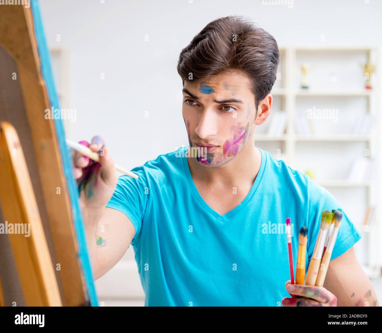 Young funny artist working on new painting in his studio Stock Photo ...