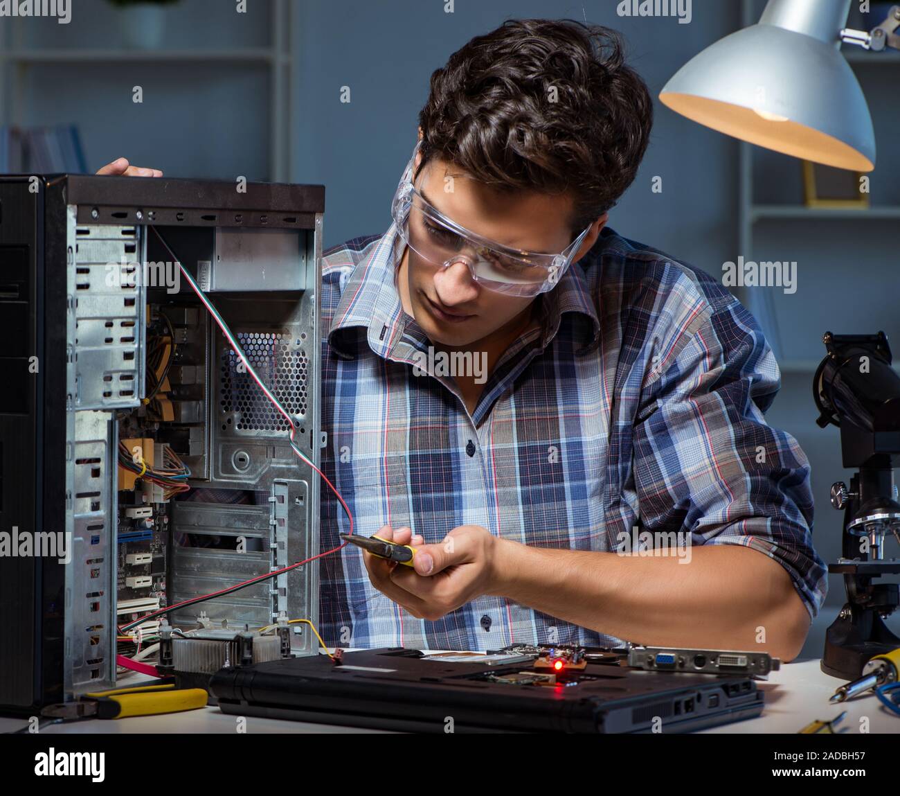 Man repairing computer desktop with pliers Stock Photo - Alamy