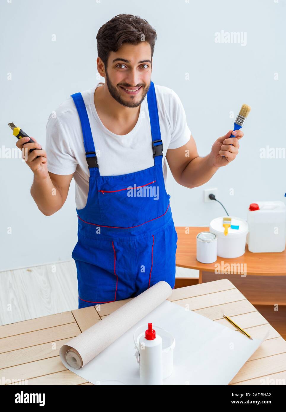 Worker working on wallpaper during refurbishment Stock Photo - Alamy
