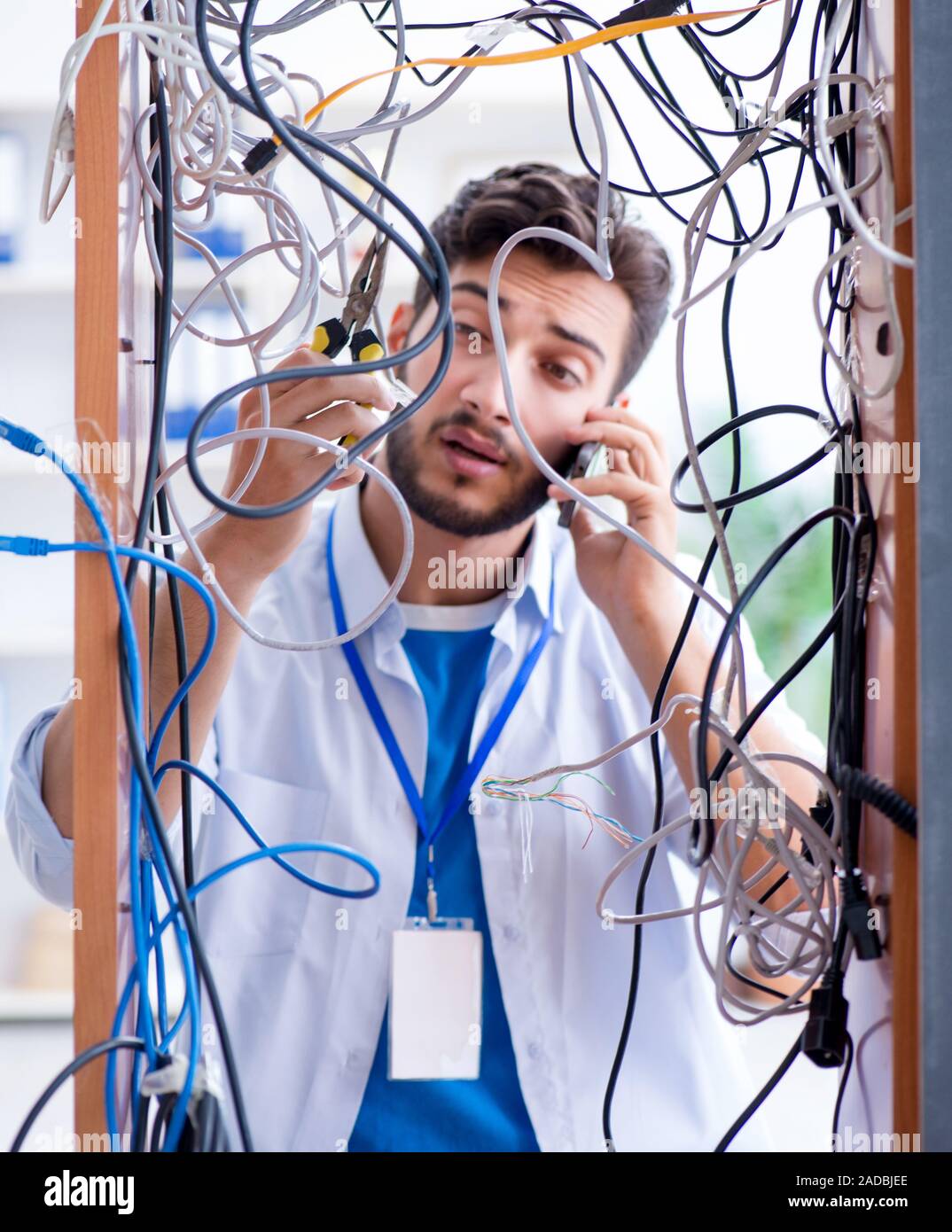 Electrician trying to untangle wires in repair concept Stock Photo - Alamy
