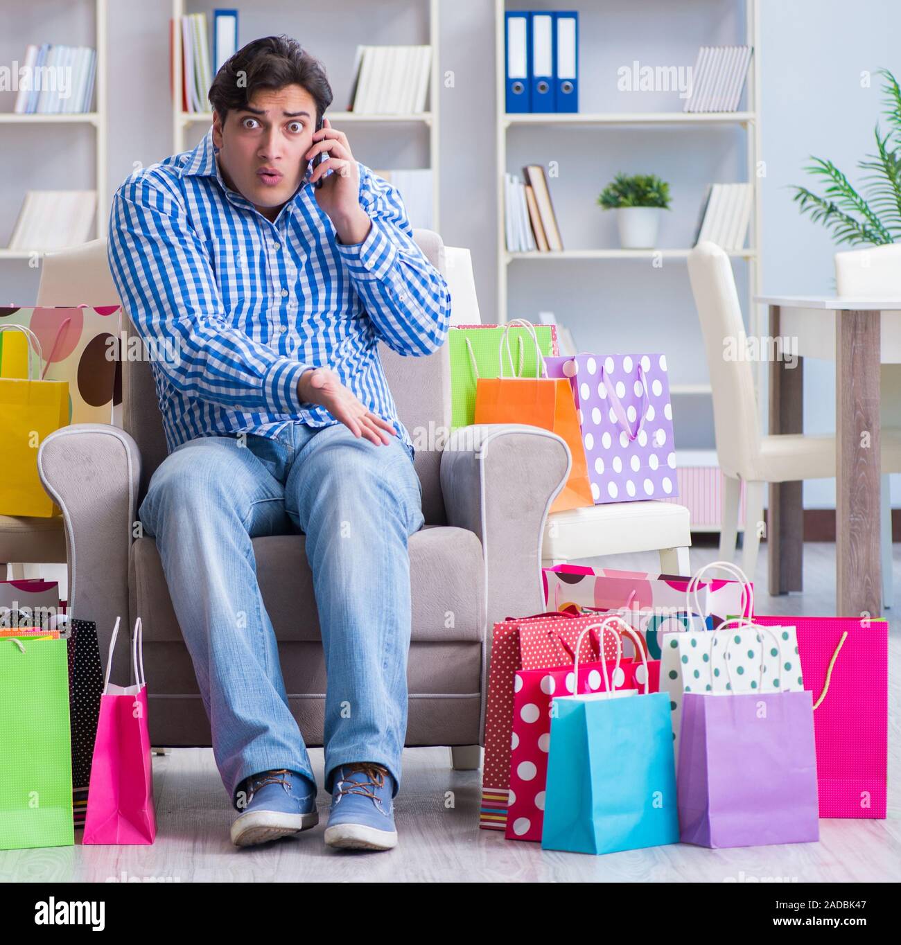 Young man after excessive shopping at home Stock Photo - Alamy