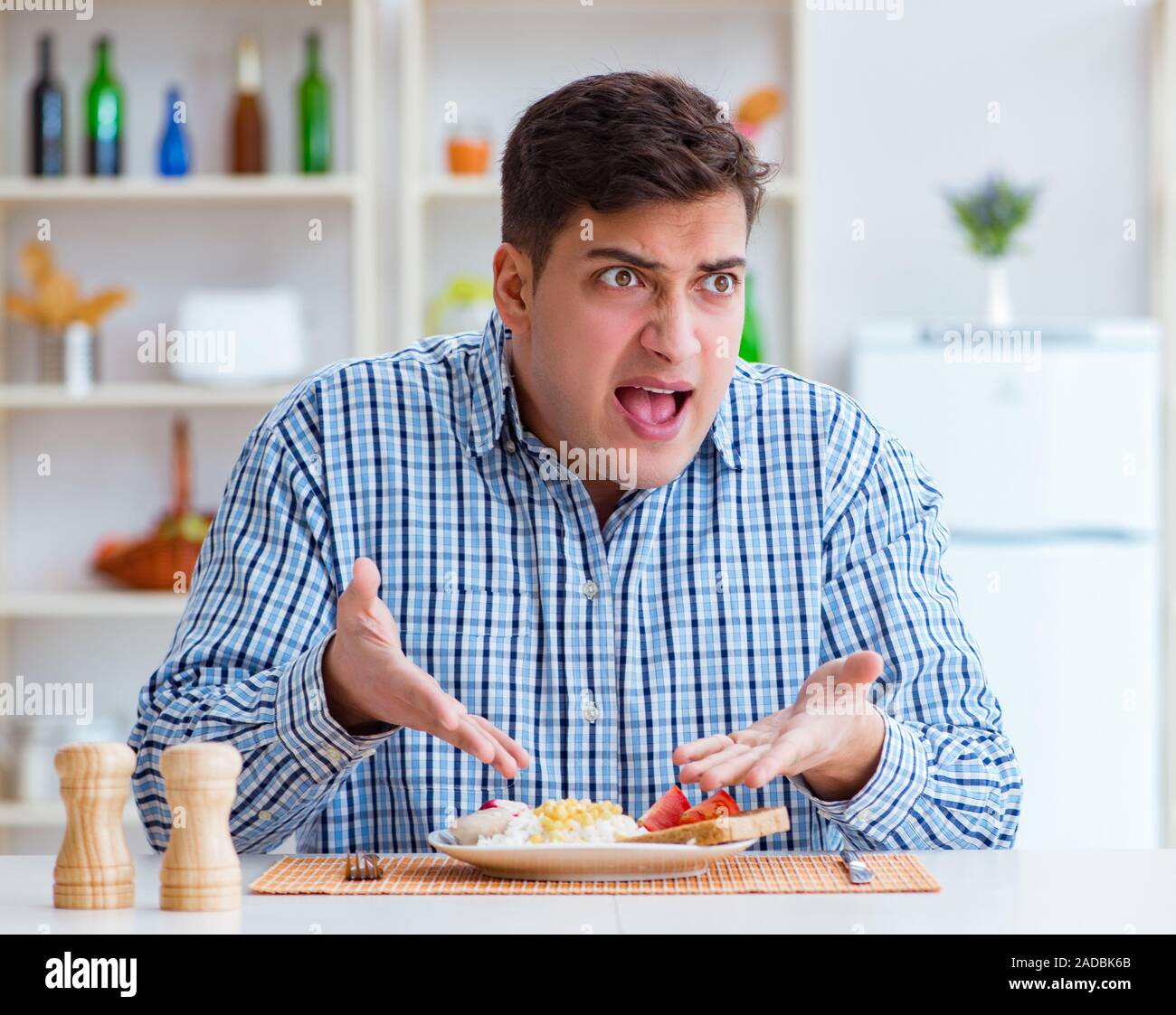 Young husband eating tasteless food at home for lunch Stock Photo - Alamy