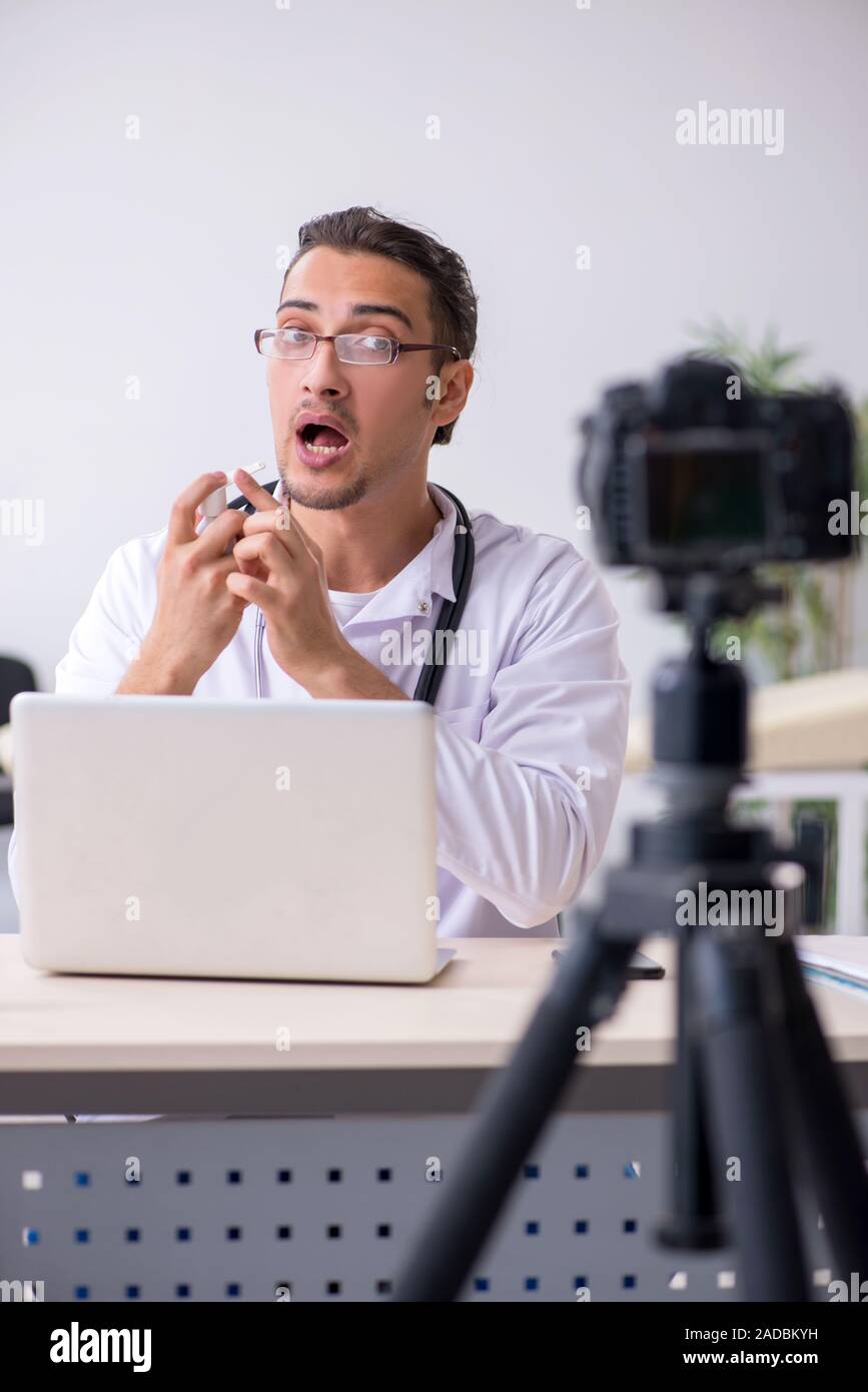 Young male doctor recording video for his blog Stock Photo - Alamy