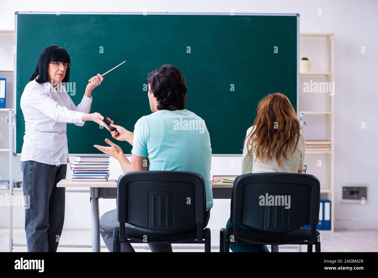 Old teacher and students in the classroom Stock Photo - Alamy