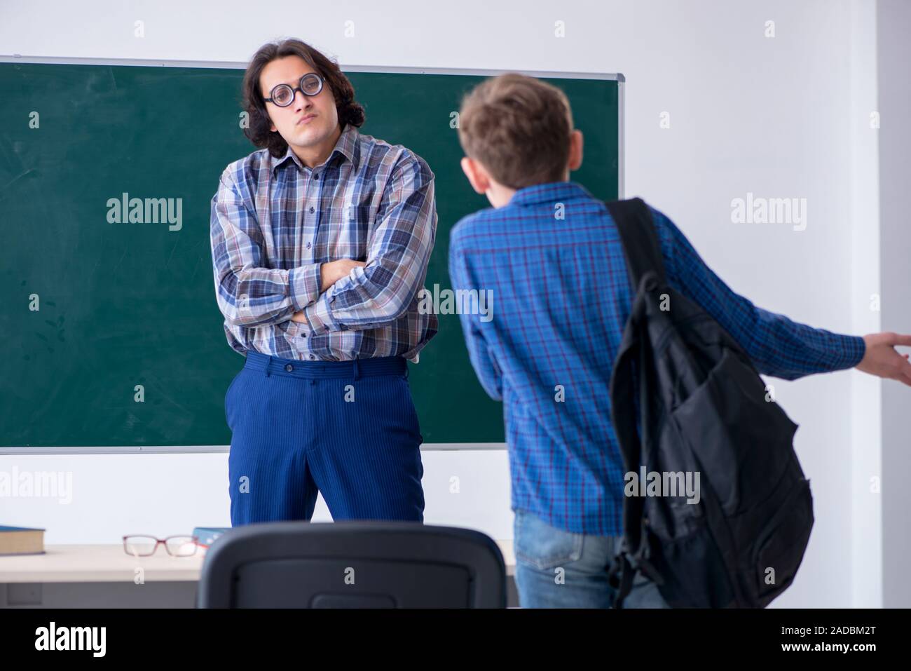 Funny male teacher and boy in the classroom Stock Photo - Alamy