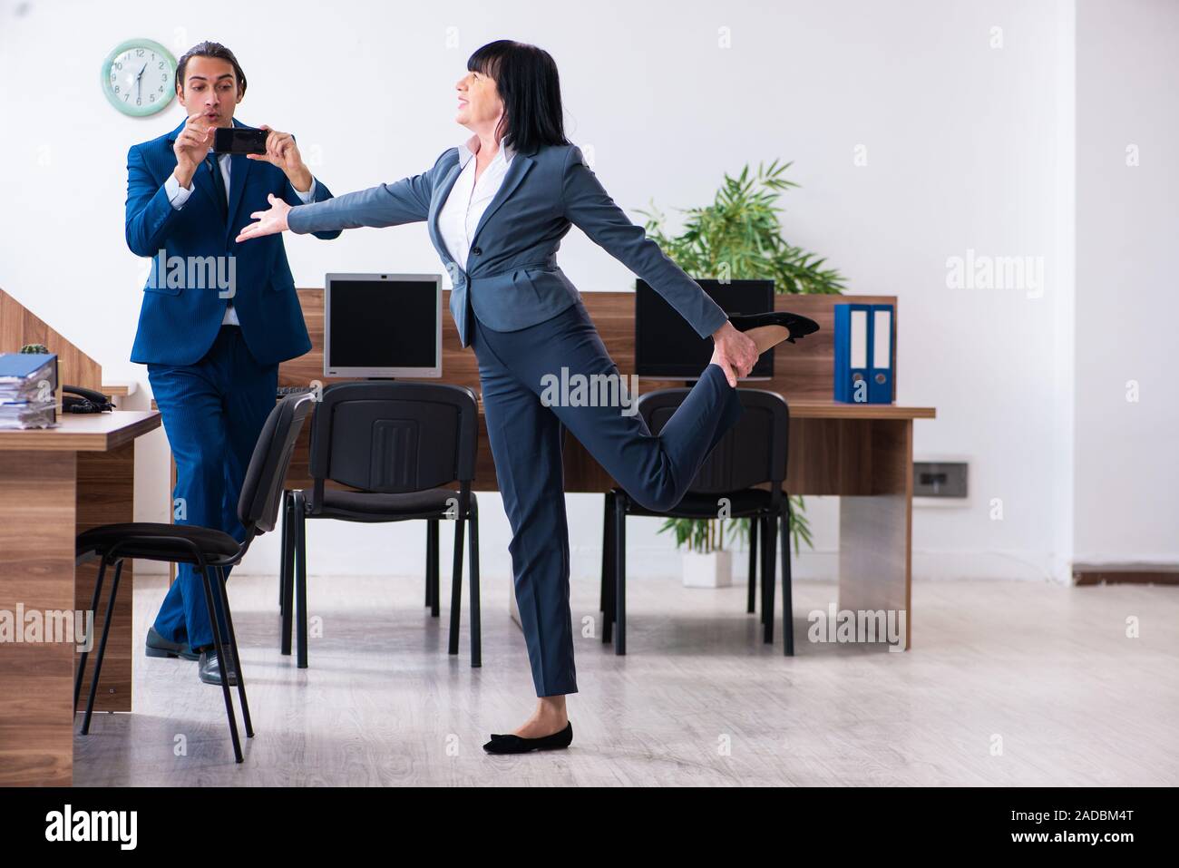 Two employees doing sport exercises in the office Stock Photo - Alamy