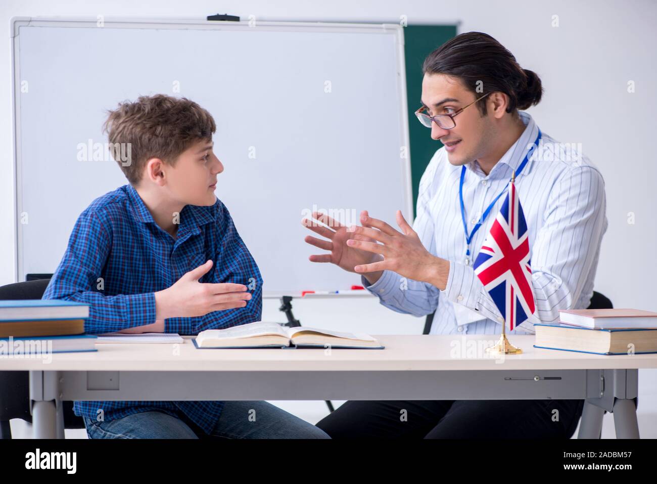 Male english teacher and boy in the classroom Stock Photo - Alamy