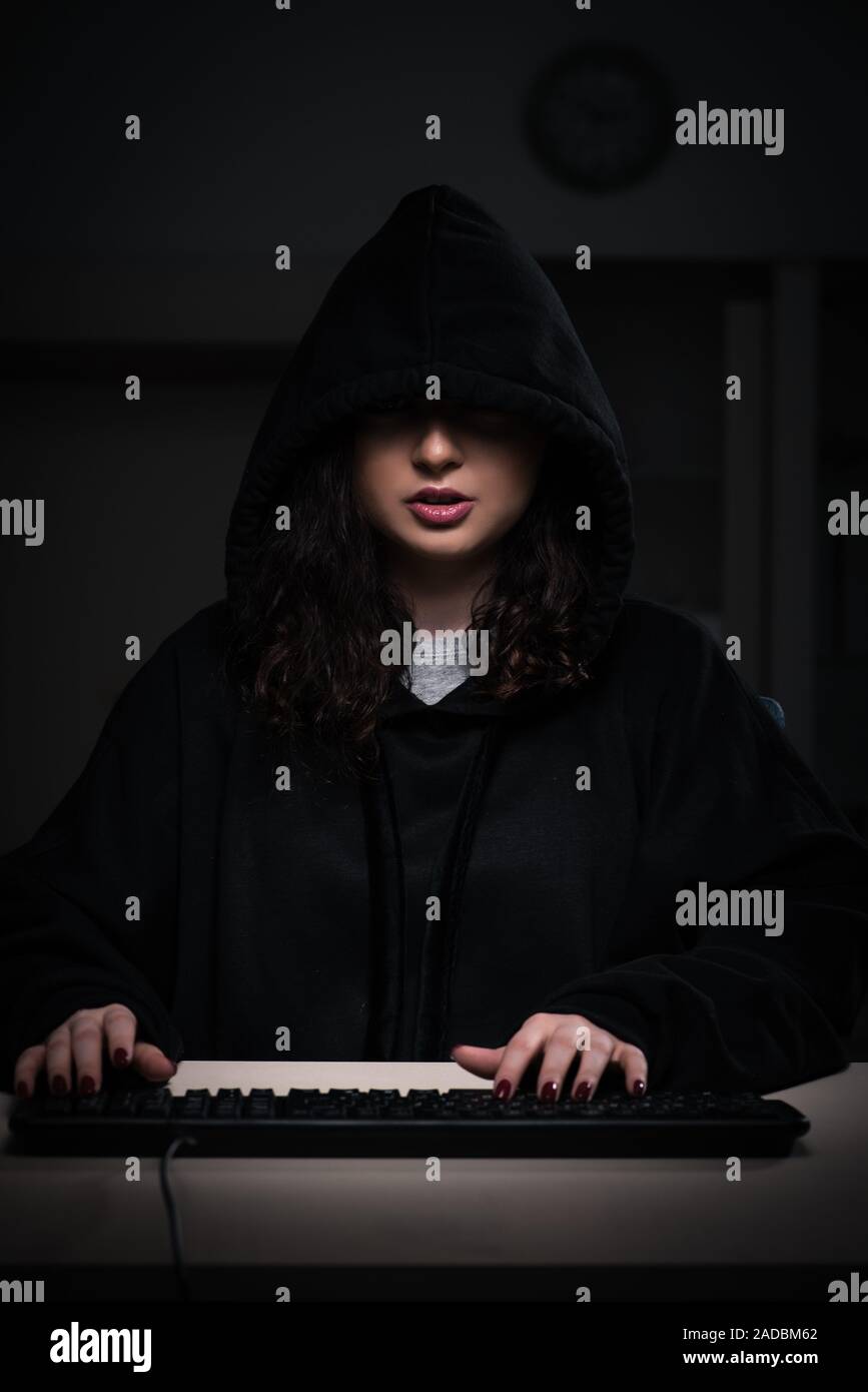 Female hacker hacking security firewall late in office Stock Photo - Alamy