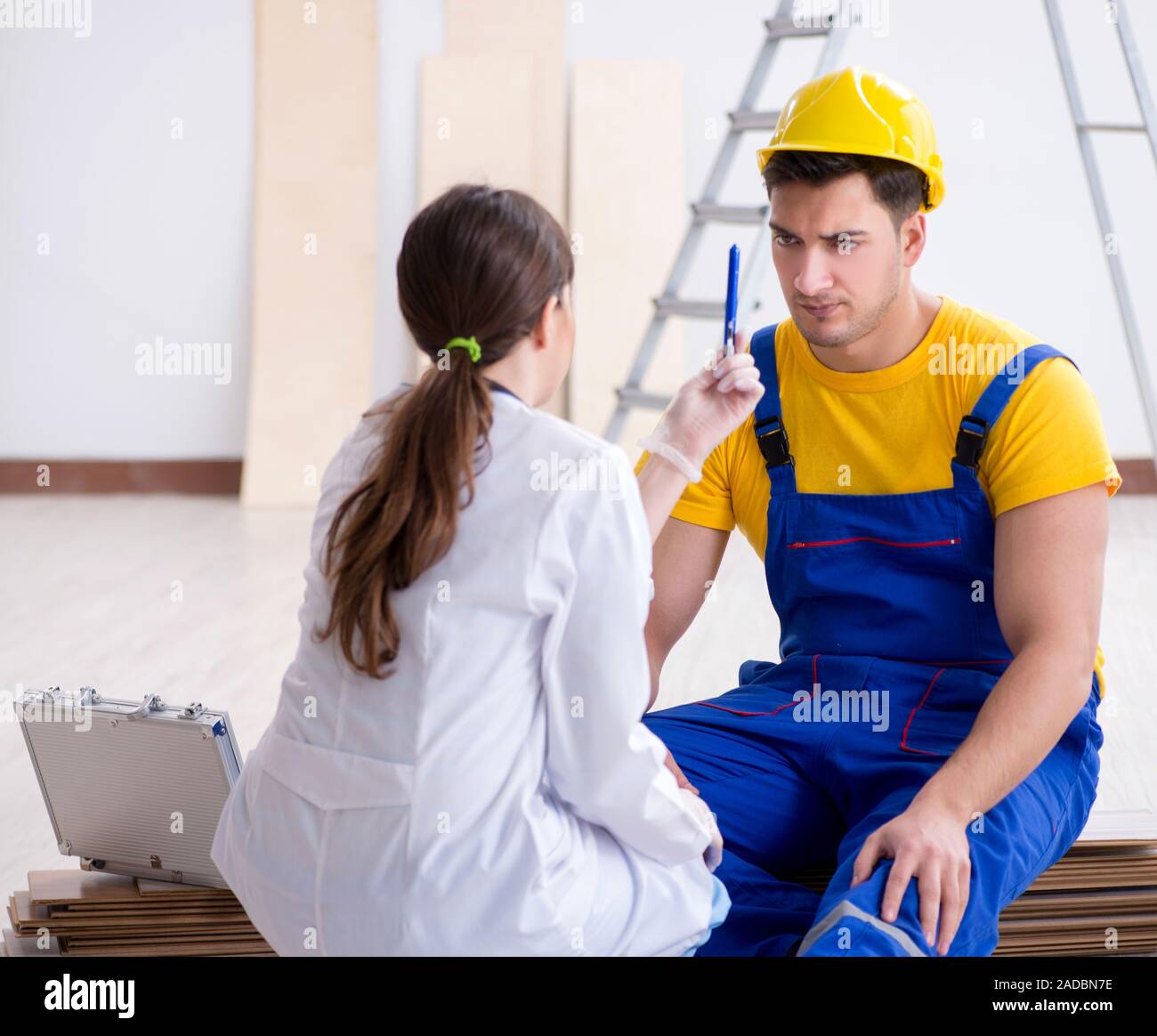 Doctor helping injured worker at construction site Stock Photo - Alamy