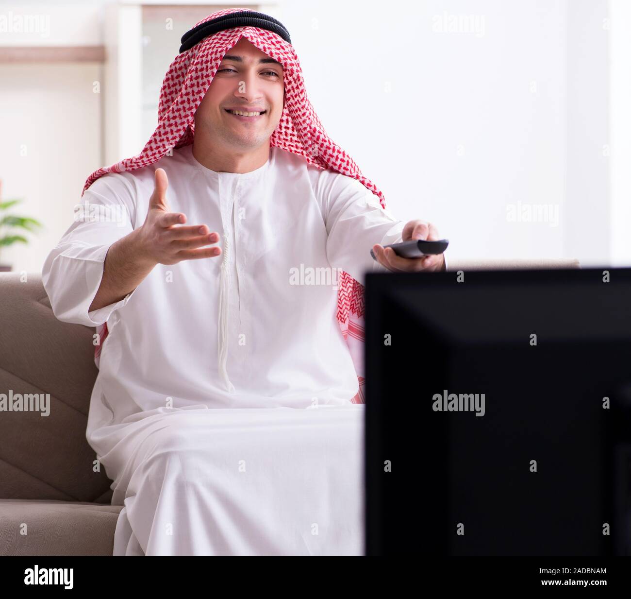 Arab man watching tv at home Stock Photo - Alamy