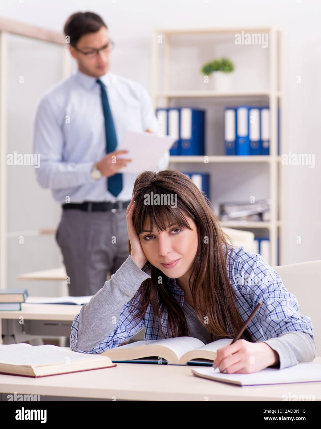 Male lecturer giving lecture to female student Stock Photo - Alamy