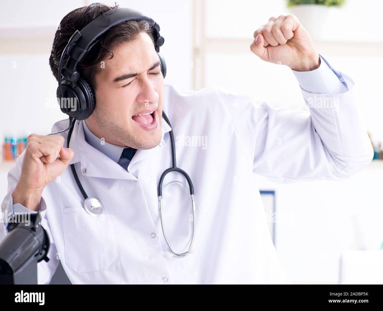 Happy excited doctor listening to music during lunch break in ho Stock ...
