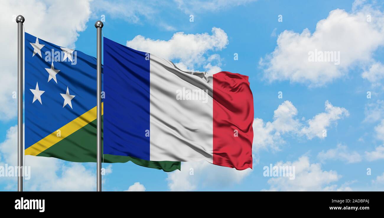 Solomon Islands and France flag waving in the wind against white cloudy ...