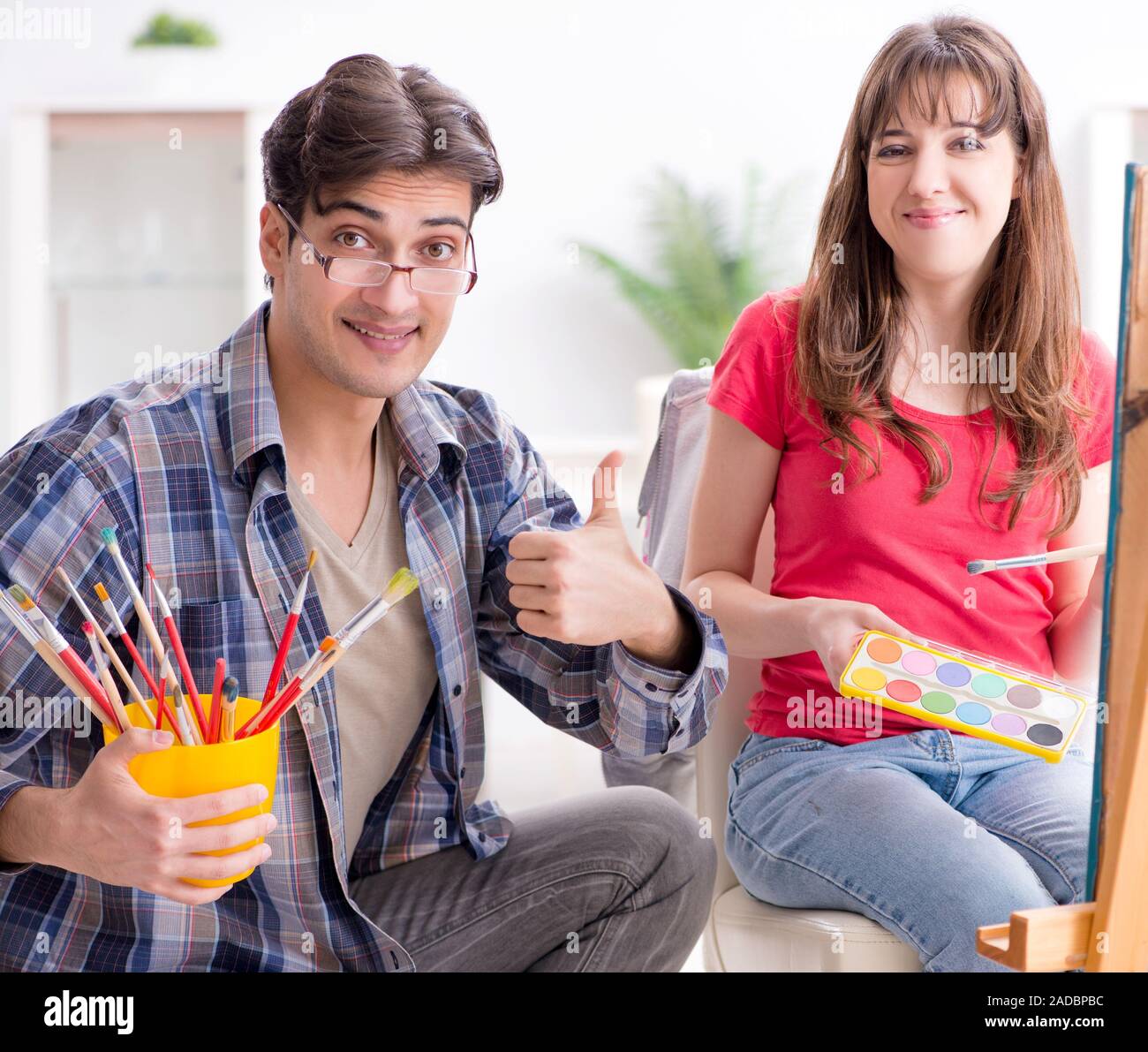 The artist coaching student in painting class in studio Stock Photo - Alamy