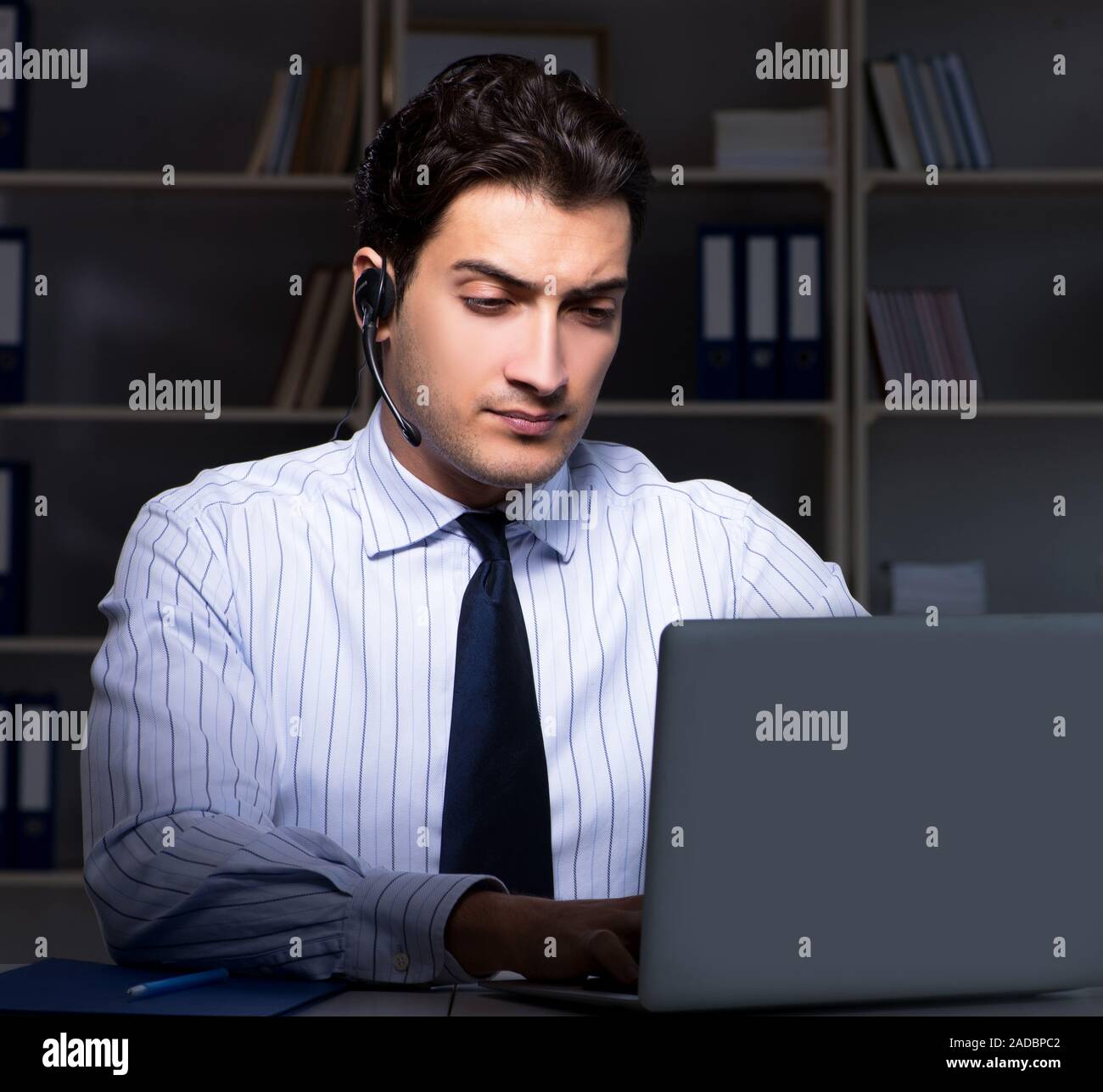 Call center operator talking to customer during night shift Stock Photo ...