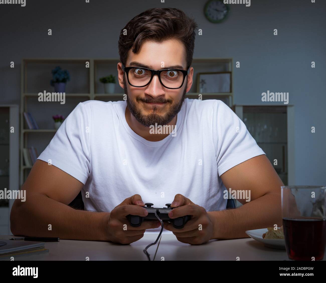 Young man playing games long hours late in the office Stock Photo - Alamy