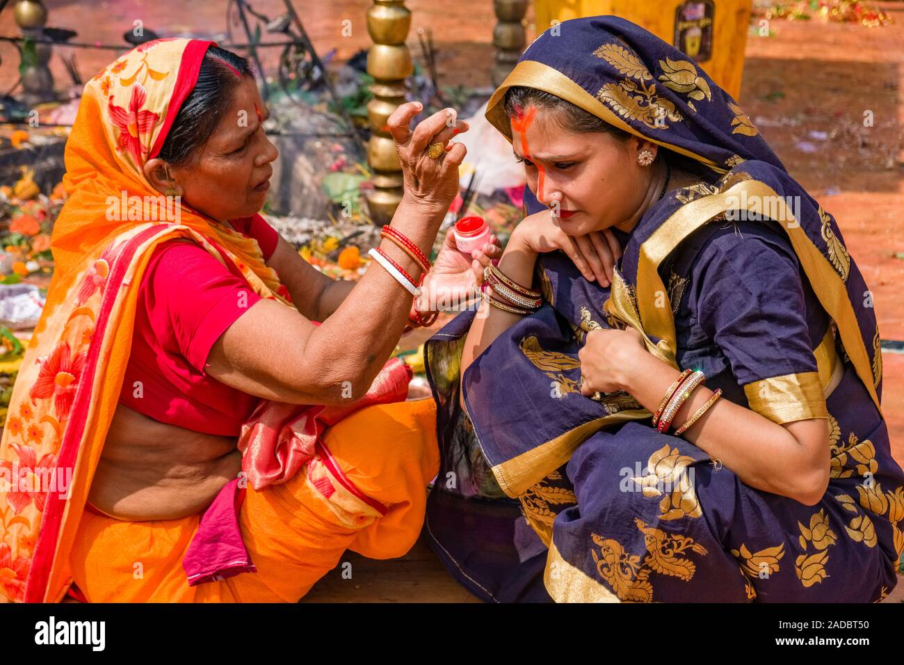 Women, painting each other a Tilak, taking part in the Khoich ceremony ...