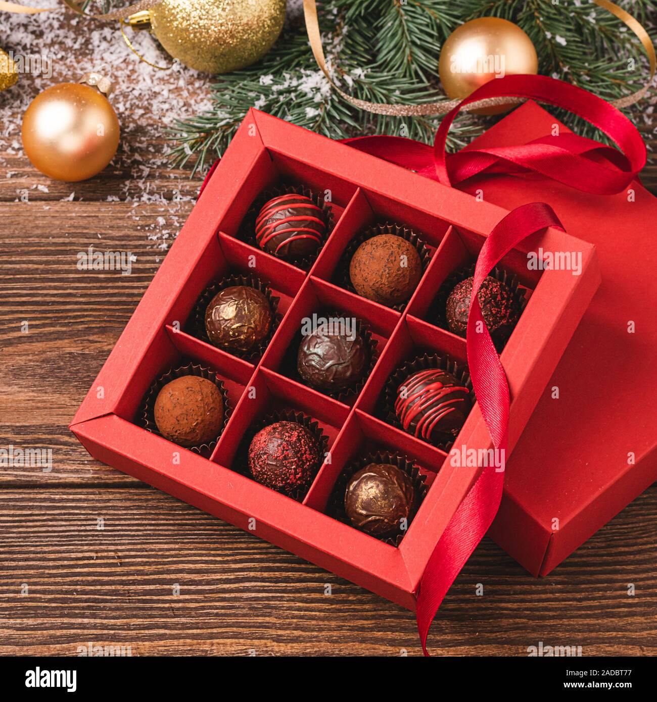 Chocolate candies in a red craft box on a wooden background Christmas ...