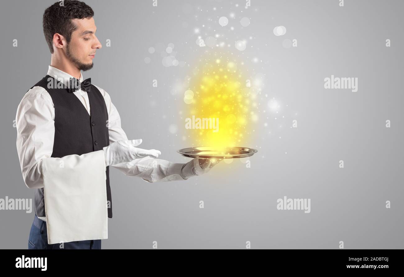 Elegant young waiter serving mysterious light on tray Stock Photo - Alamy