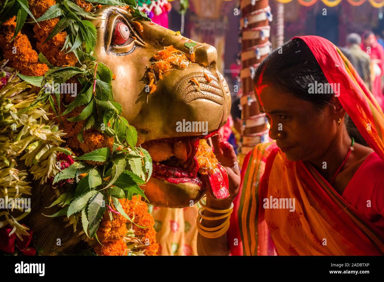 Women, praying at a golden lion statue, taking part in the Khoich ...