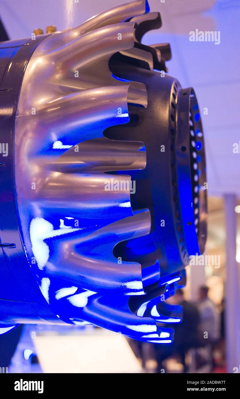 A jet engine exhaust nozzle or mixer illuminated in blue light. Also ...