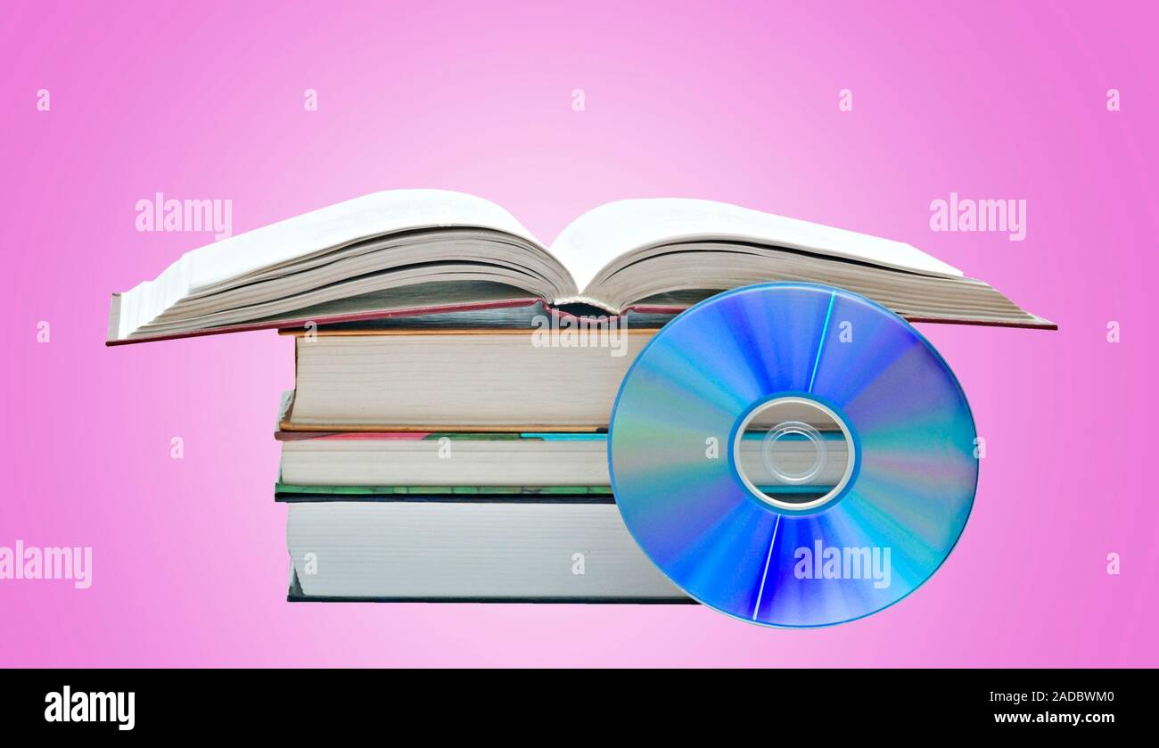 Pile of books, open book, and DVD disk as symbols of old and new ...