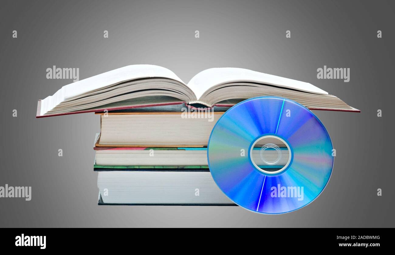 Pile of books, open book, and DVD disk as symbols of old and new ...
