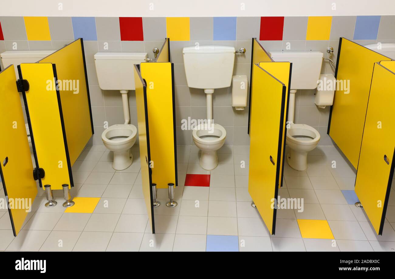 three toilets of a bathroom nursery with yellow doors without the kids ...