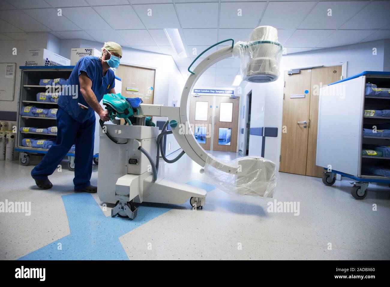 X-ray machine. Technician moving an X-ray machine through into a ...