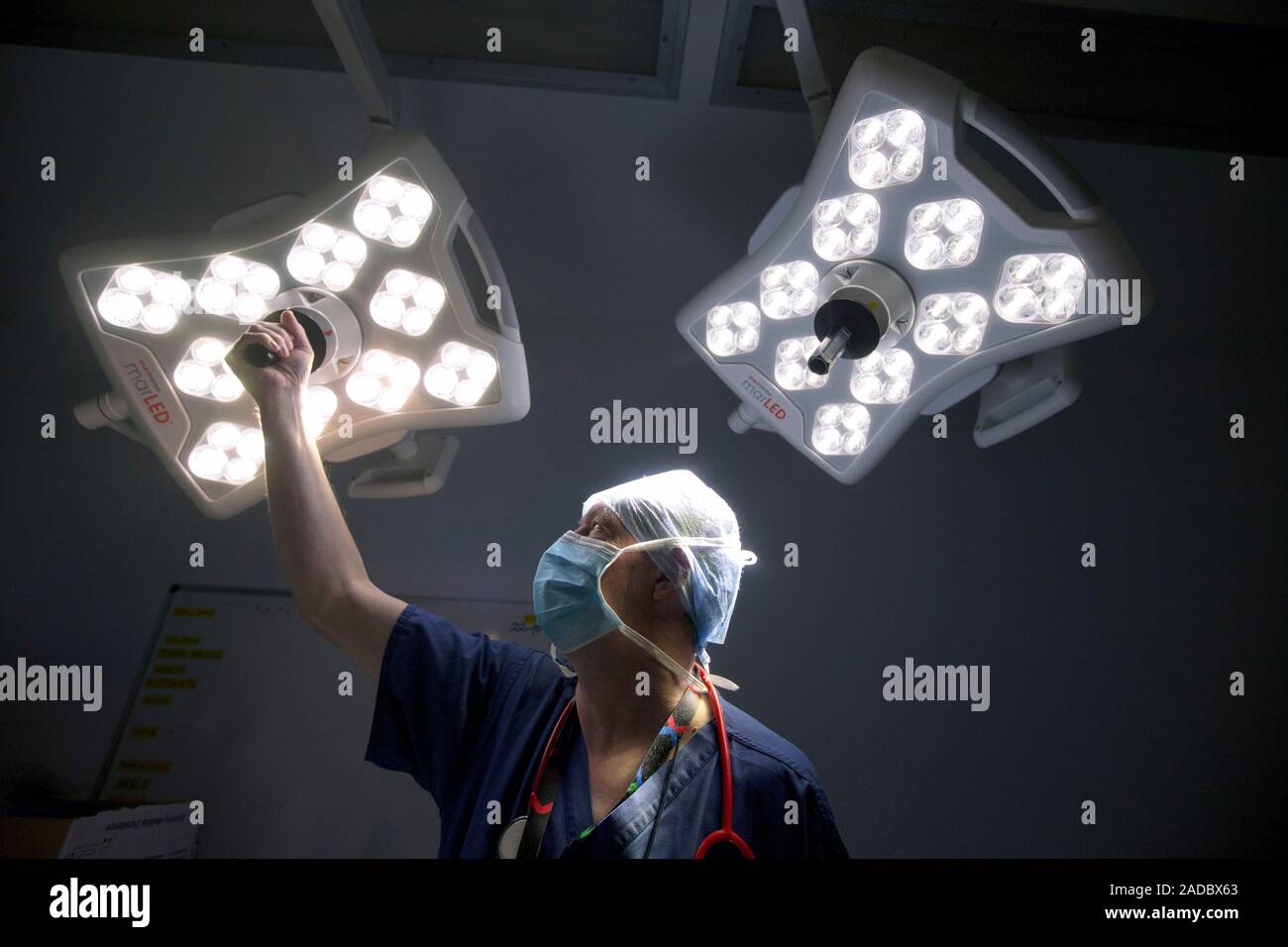 Operating theatre lighting. Theatre technician adjusting the lights in ...