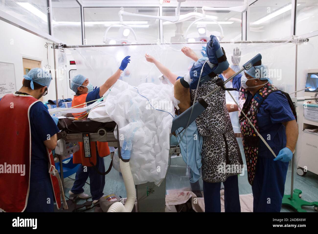Preparing for surgery. Surgical staff preparing a patient and operating ...