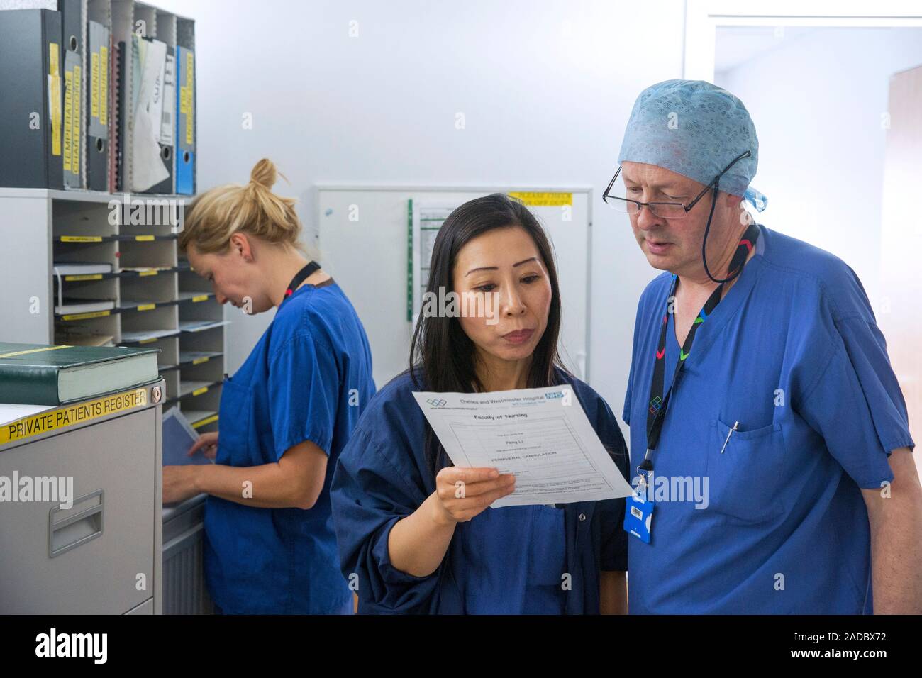 Surgical staff. Surgeon discussing notes with surgical staff Stock ...