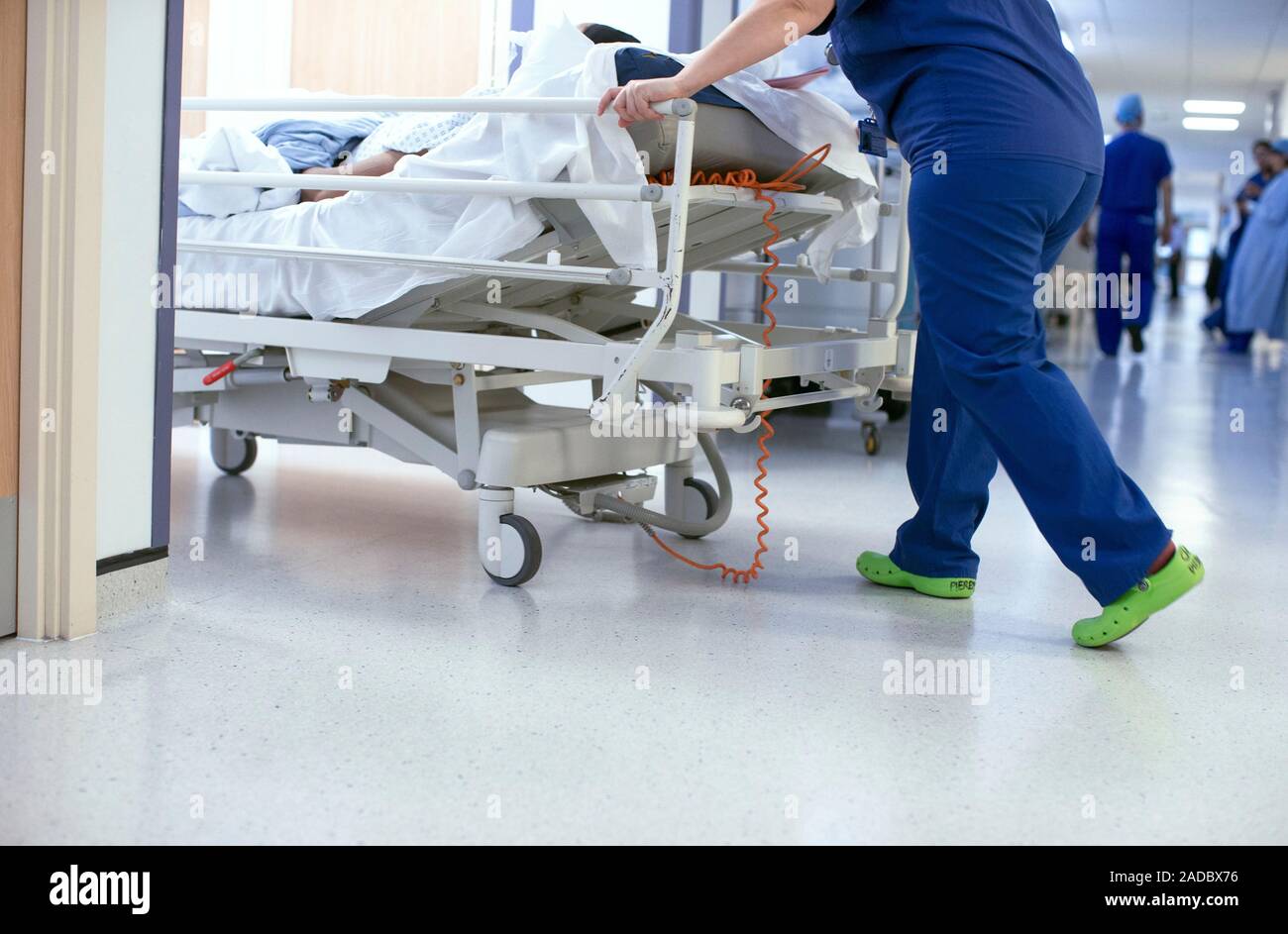 Hospital operation. Patient being wheeled into an operating theatre for ...