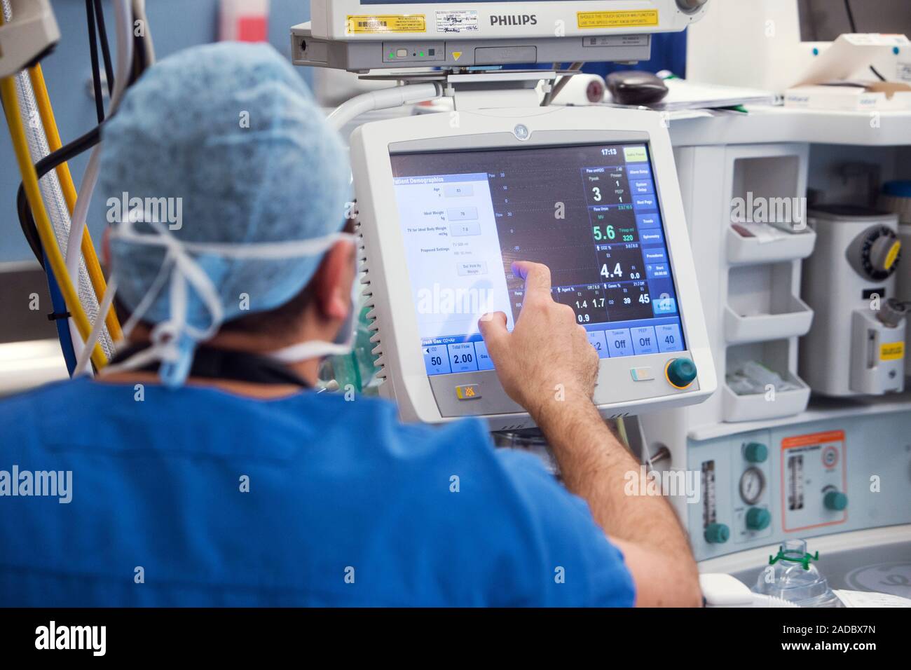 Anaesthetist at work. Anaesthetist checking a patient's drug dosage on ...