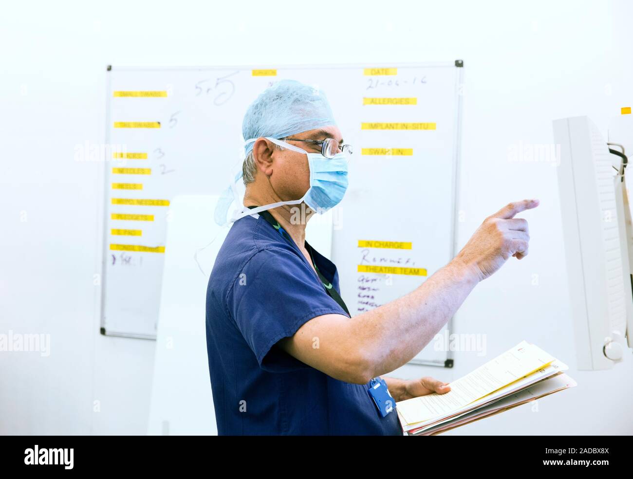Surgeon at work. Surgeon checking patient's details on a screen during ...